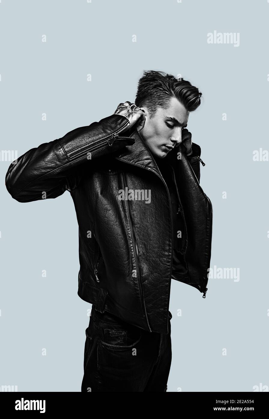 Caucasian young man posing isolated over light studio background. Side ...