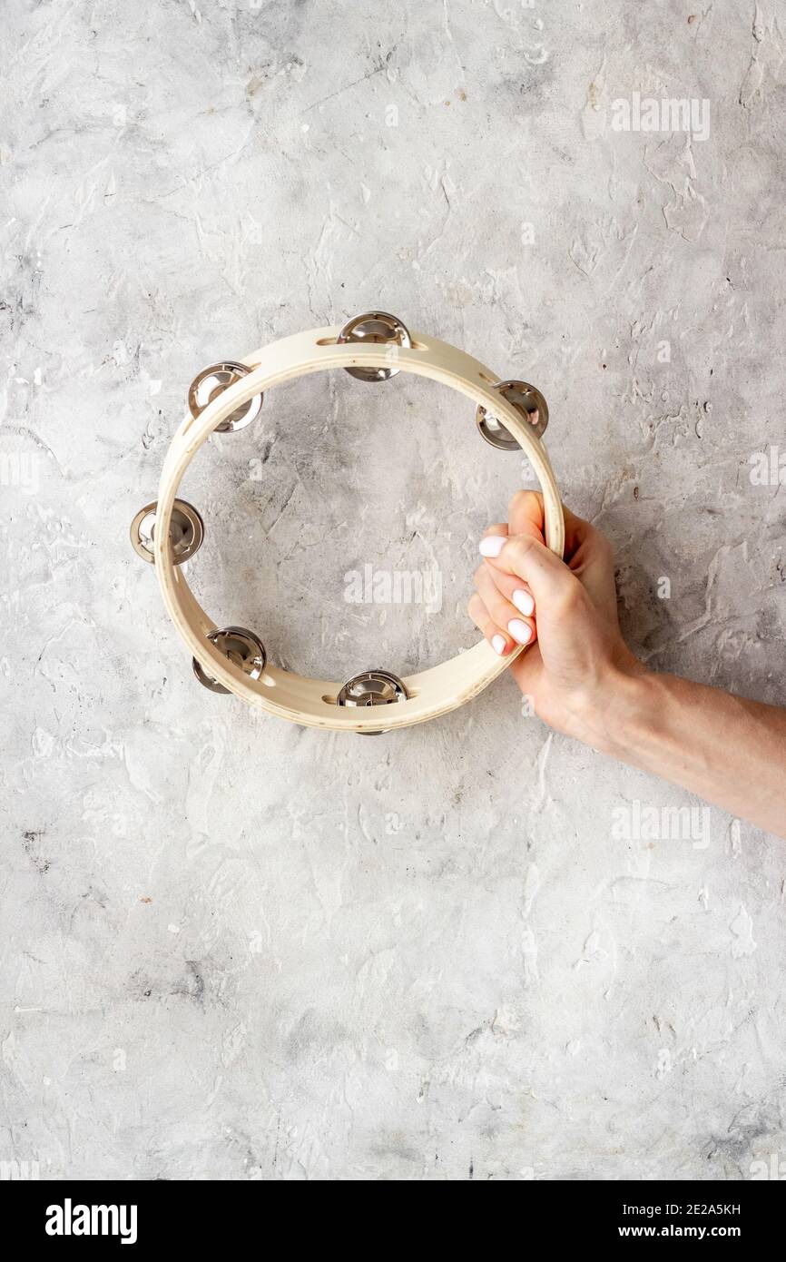 Wooden tambourine in hand. Percussion musical instrument, top view ...