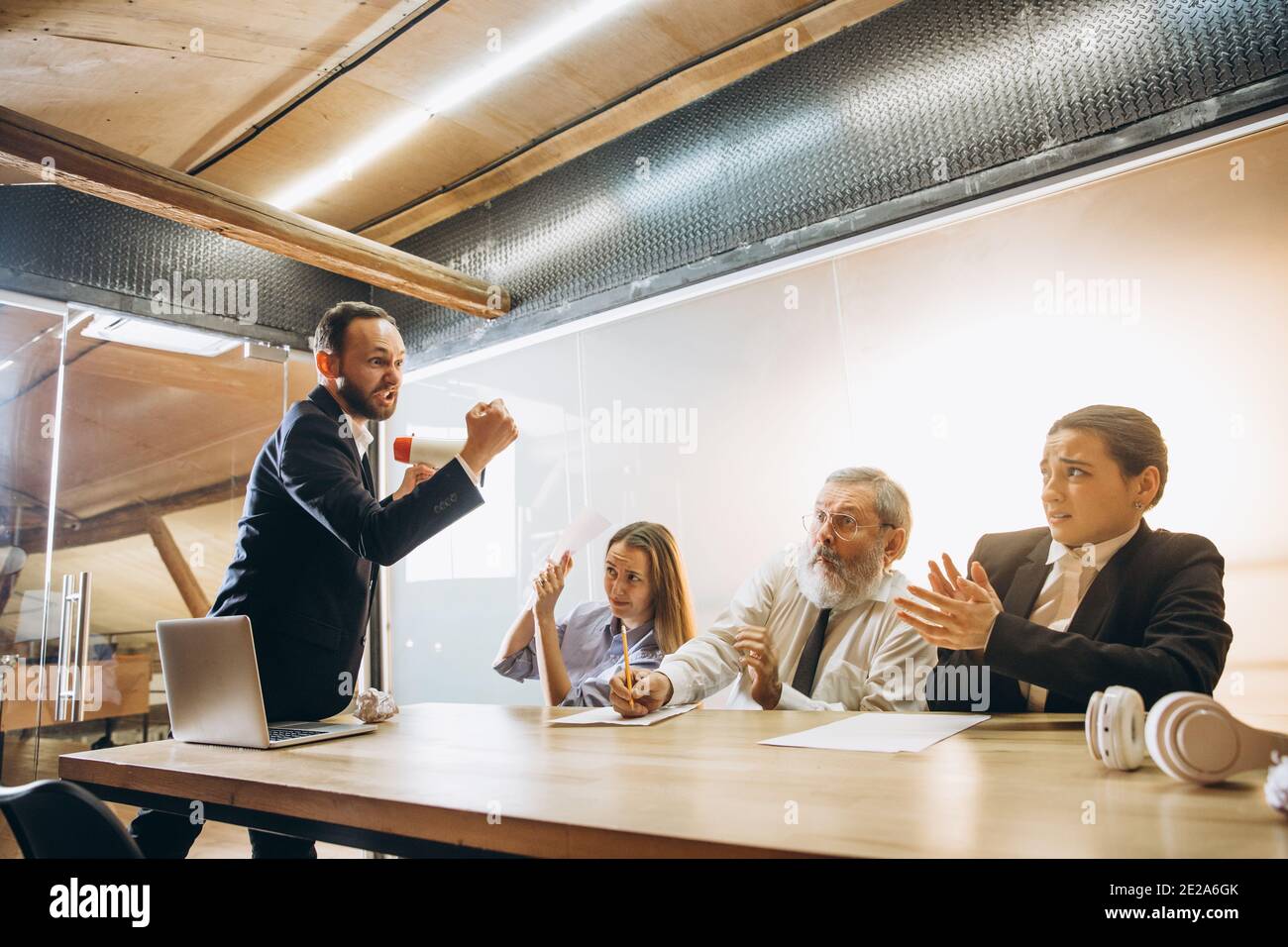 Fight. Angry boss with megaphone screaming at employees in office ...