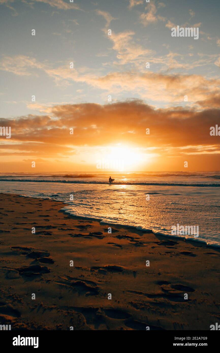 Vertical shot of the amazing sunset above the ocean - shot from a sandy ...