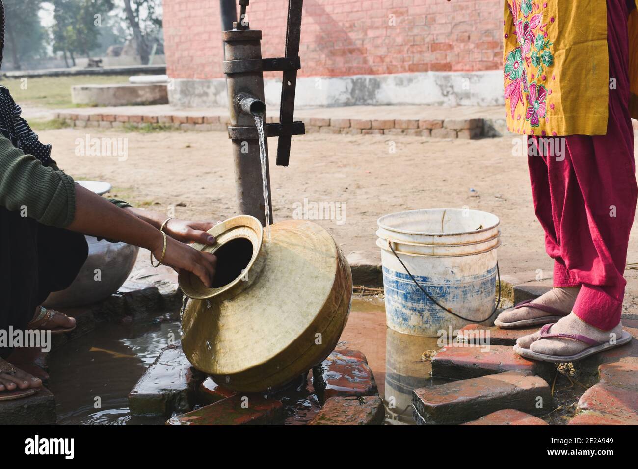 Female gathering water from a water supply Stock Photo - Alamy