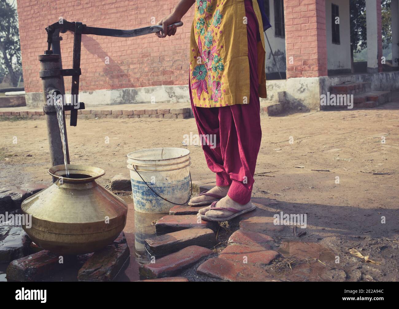 Female gathering water from a water supply Stock Photo - Alamy