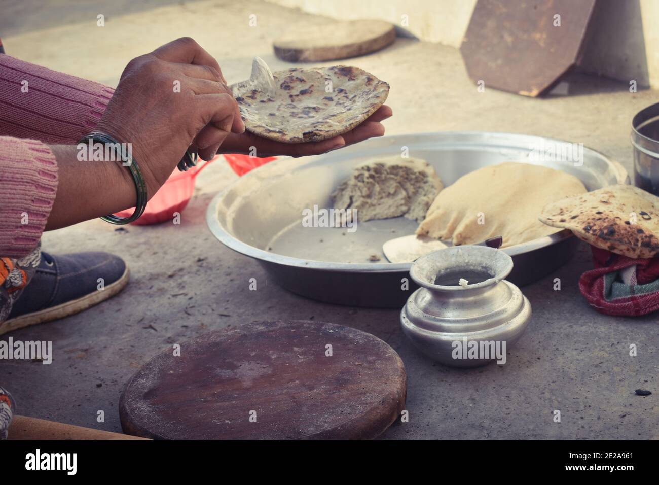 Rural Indian female topping chapati with clarified butter Stock Photo ...