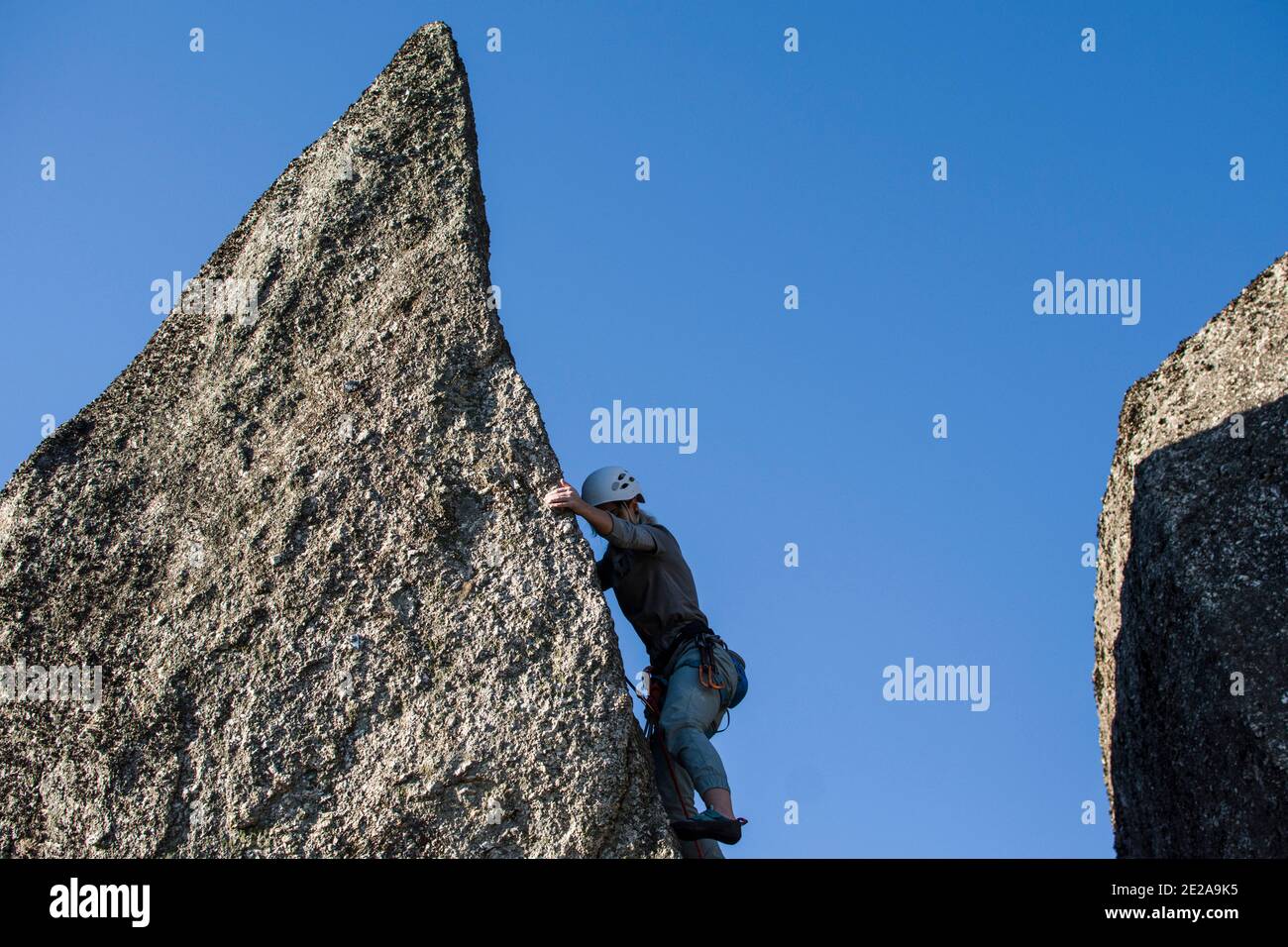 Woman rock climbing up cliff hi-res stock photography and images - Alamy