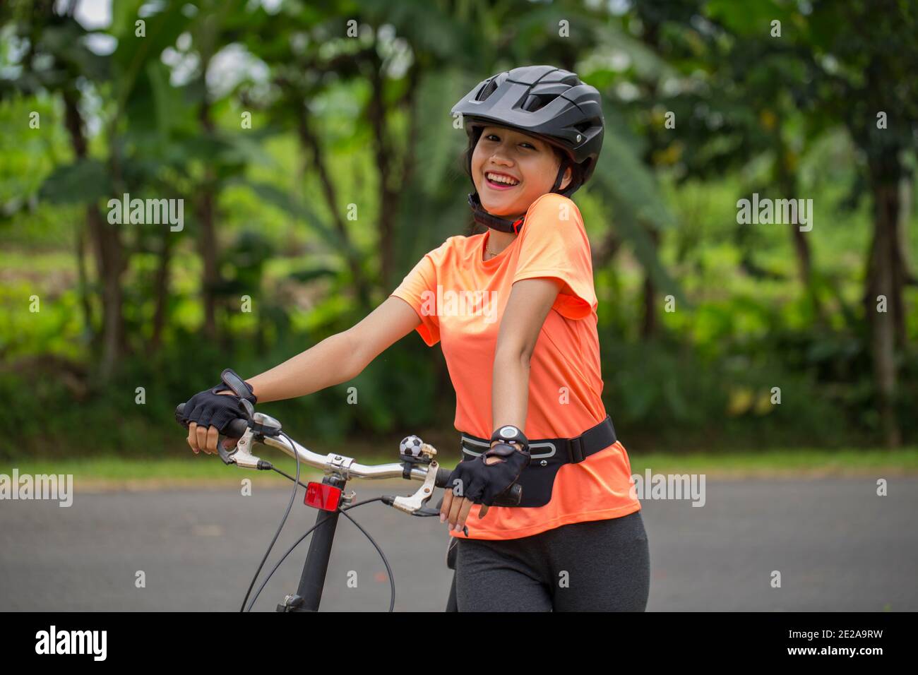 portrait of young asian woman cyclist with bike Stock Photo - Alamy