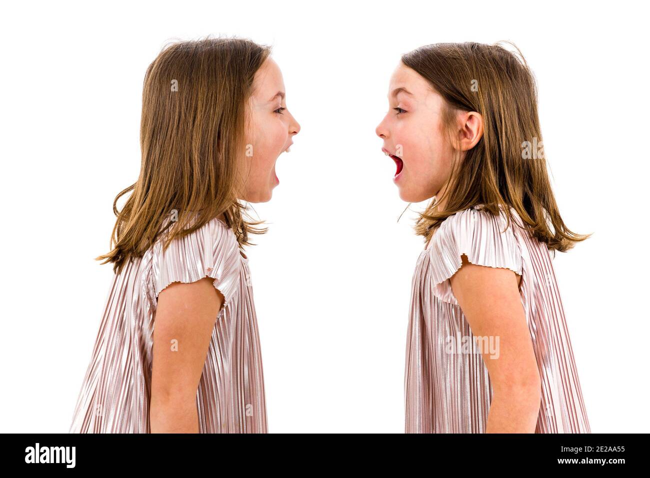 Identical twin girls are looking at each other and smiling. Concept of ...