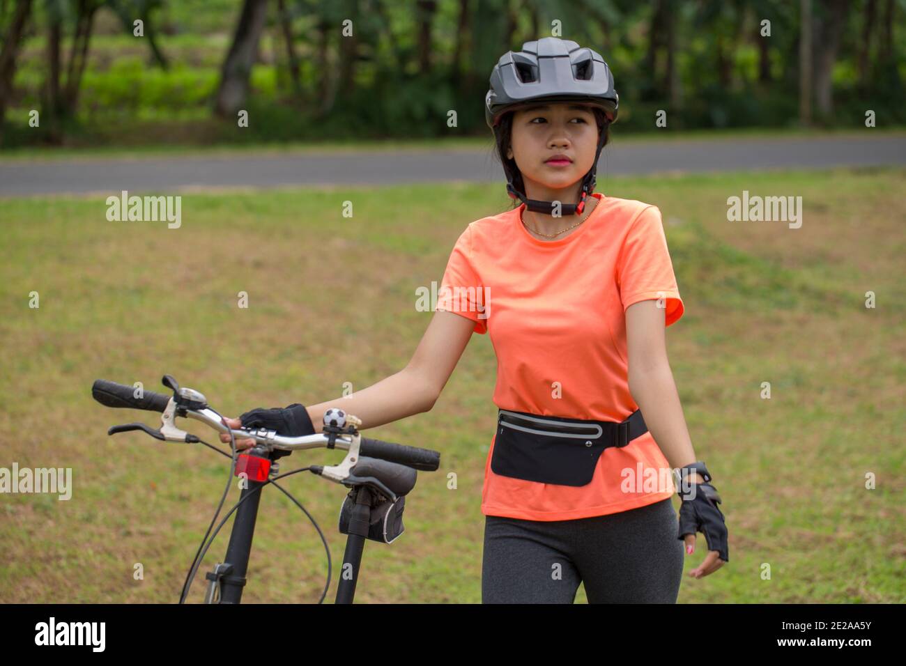 portrait of young asian woman cyclist with bike Stock Photo - Alamy