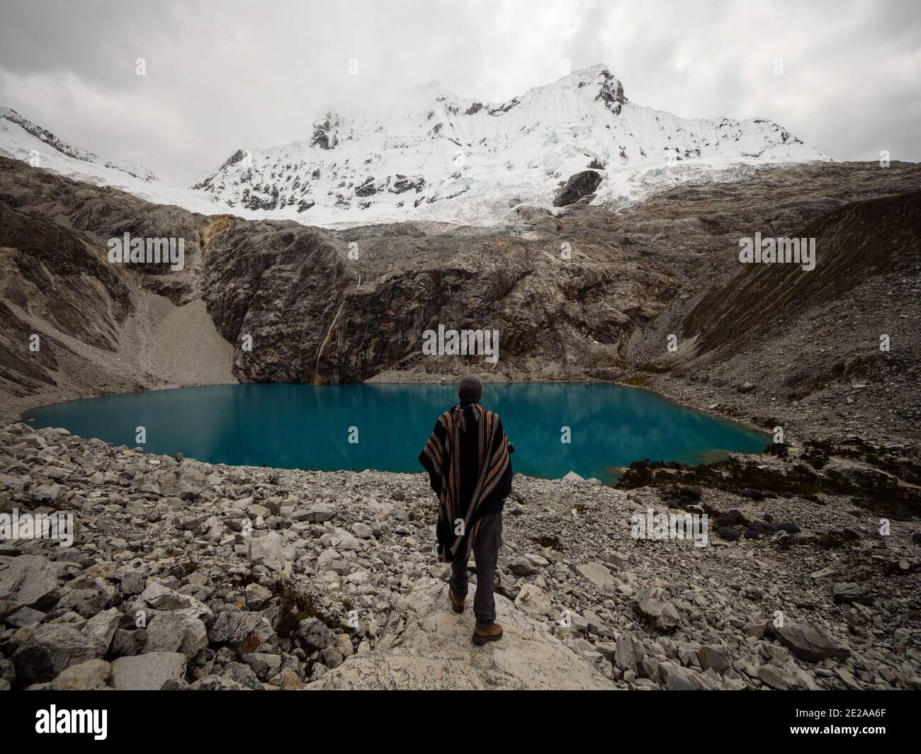 Panorama landscape view of hiker in traditional indigenous poncho cape ...