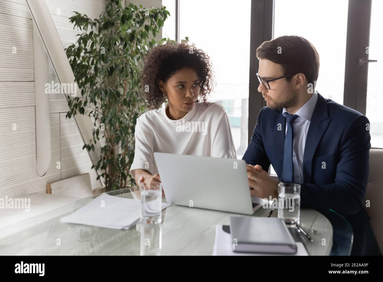 Multiracial colleagues work on laptop at meeting Stock Photo - Alamy