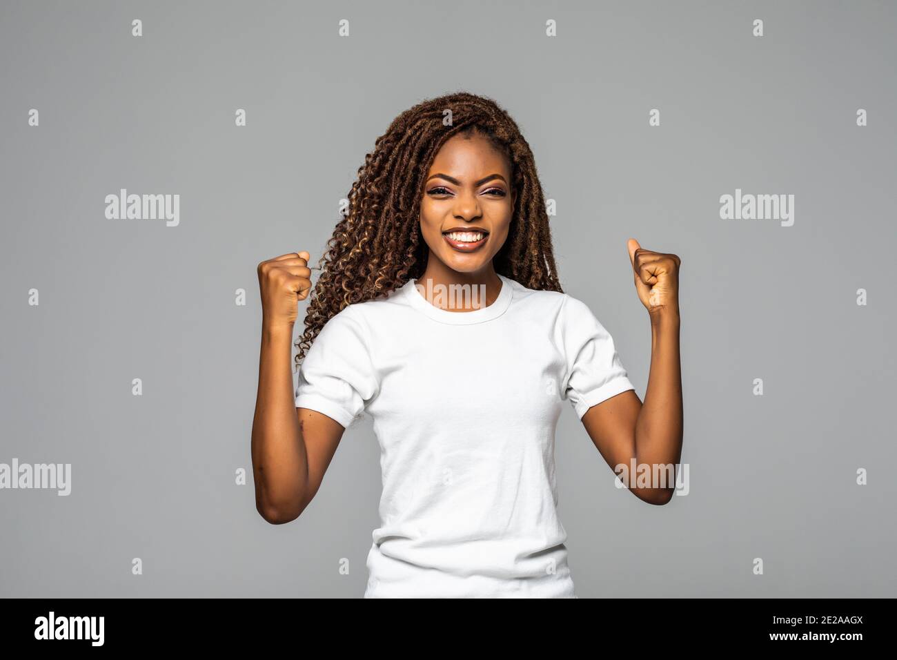 Overjoyed young african american woman screaming with joy celebrating ...