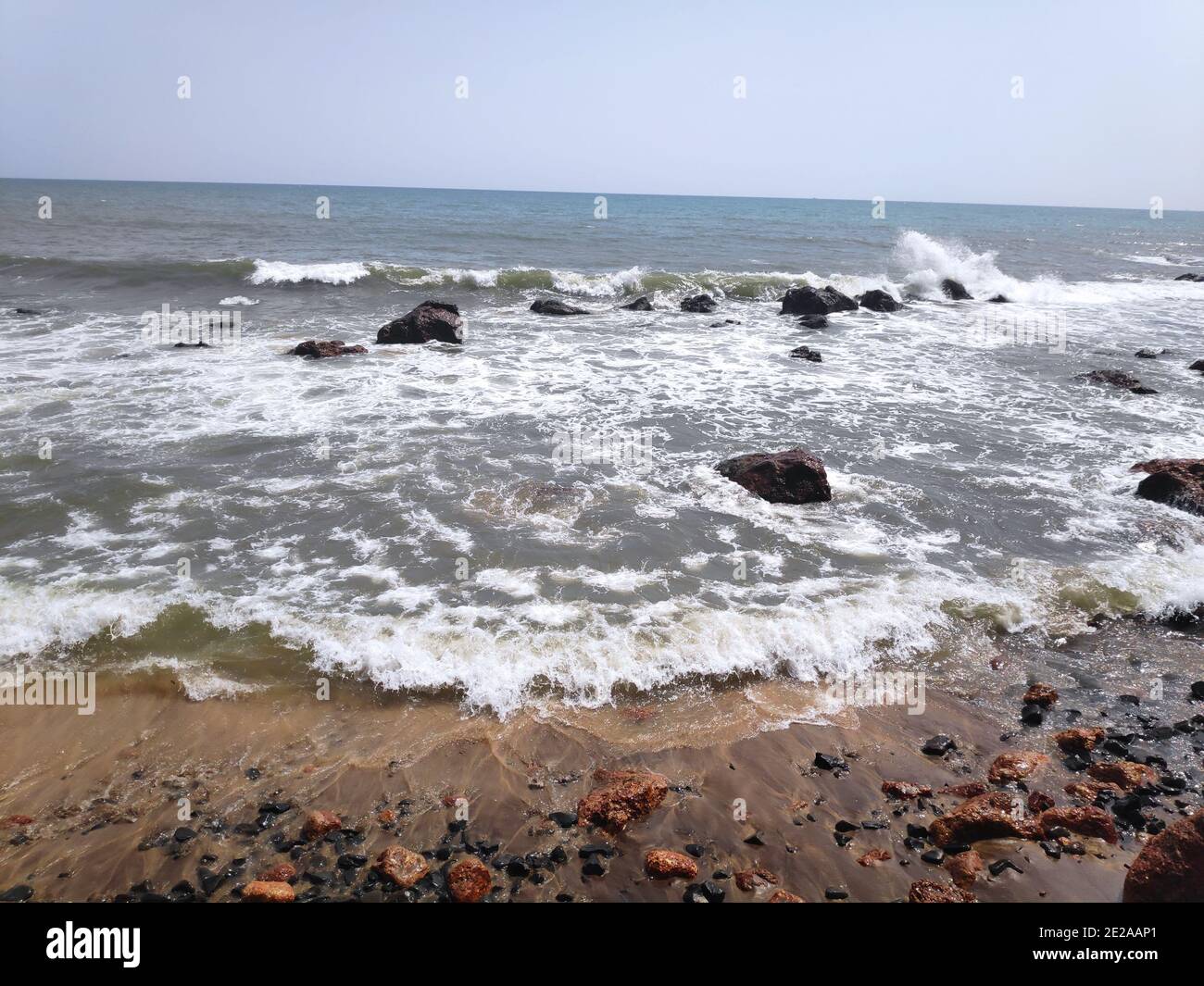 Rocky beach with a beautiful wavy seascape view of the Arabian sea in ...