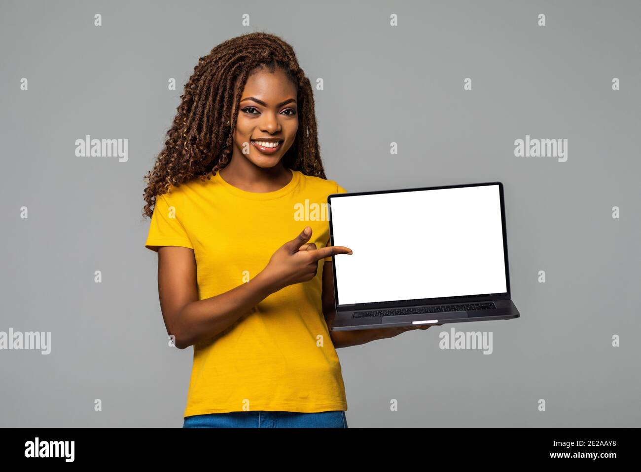 Young smiling black woman standing with laptop computer Stock Photo - Alamy