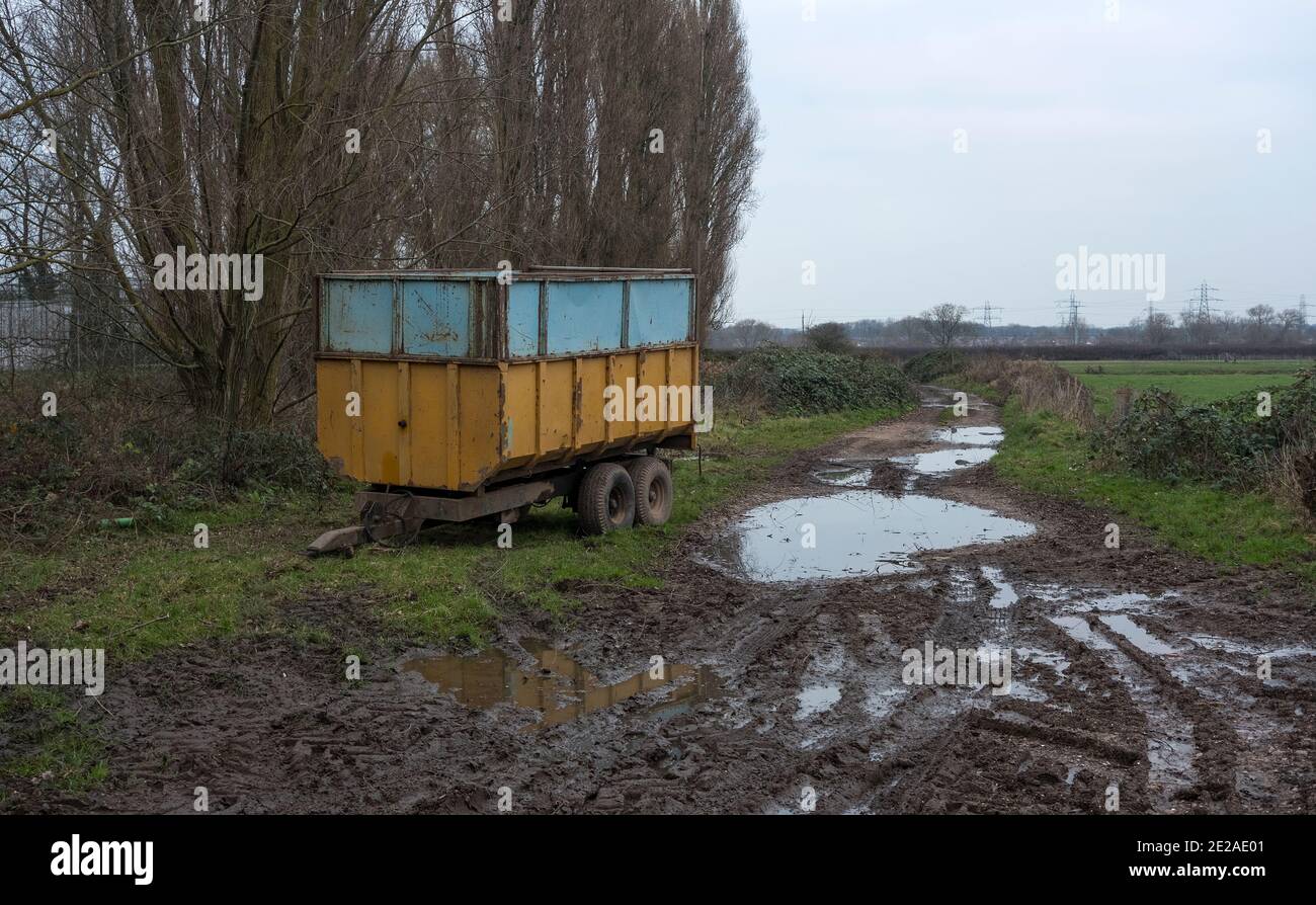 Old farm trailer next to a muddy track Stock Photo - Alamy