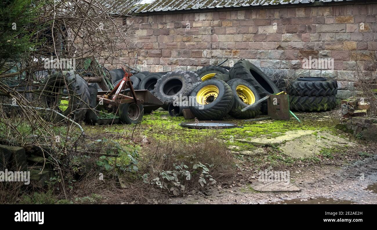 Collection of old worn tyres on a farm Stock Photo - Alamy