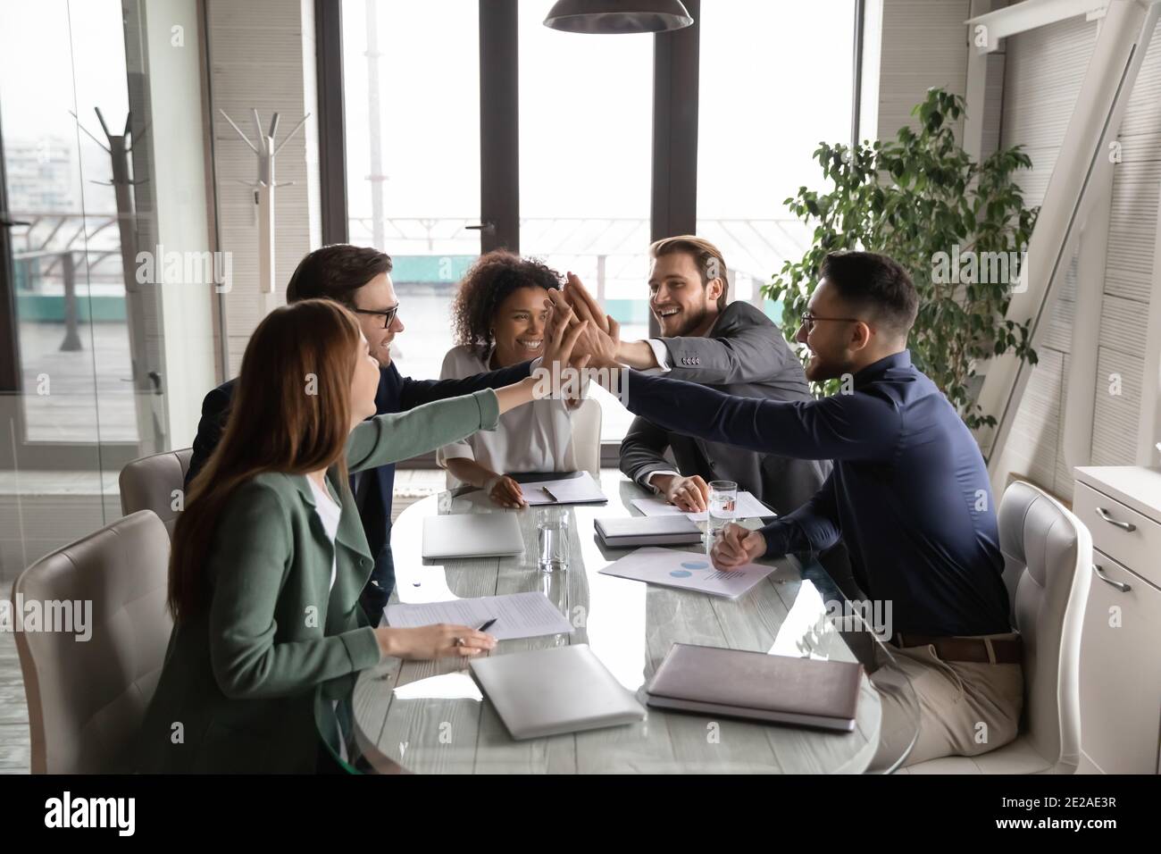 Excited diverse employees engaged in teambuilding activity at meeting ...