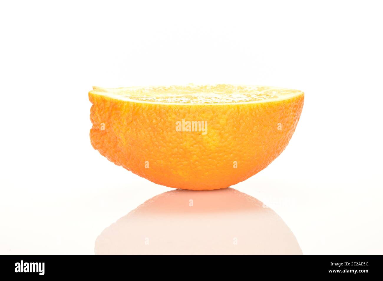 One half of a bright orange ripe fragrant orange on a white background ...