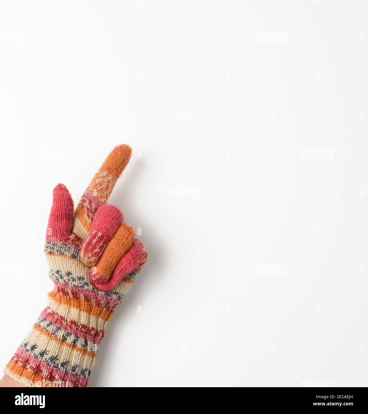female hand in a knitted mitten on a white background, the index finger ...
