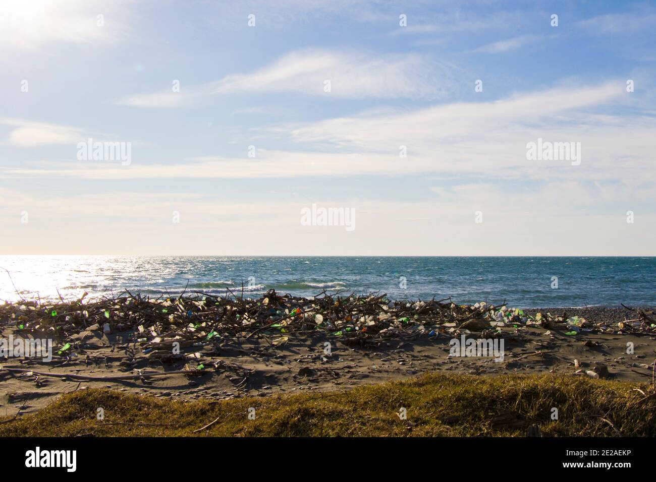Garbage on the sandy beach, plastic and metal pollution, global warming ...