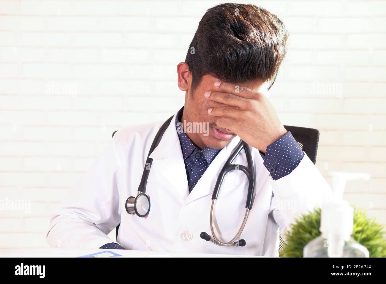 Depressed sad doctor covering face with hands Stock Photo - Alamy