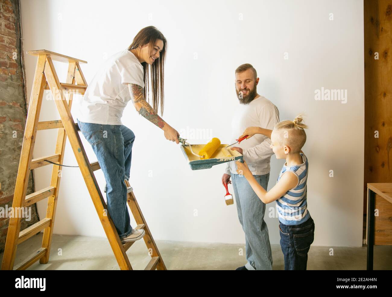 Young couple, family doing apartment repair together themselves. Mother ...
