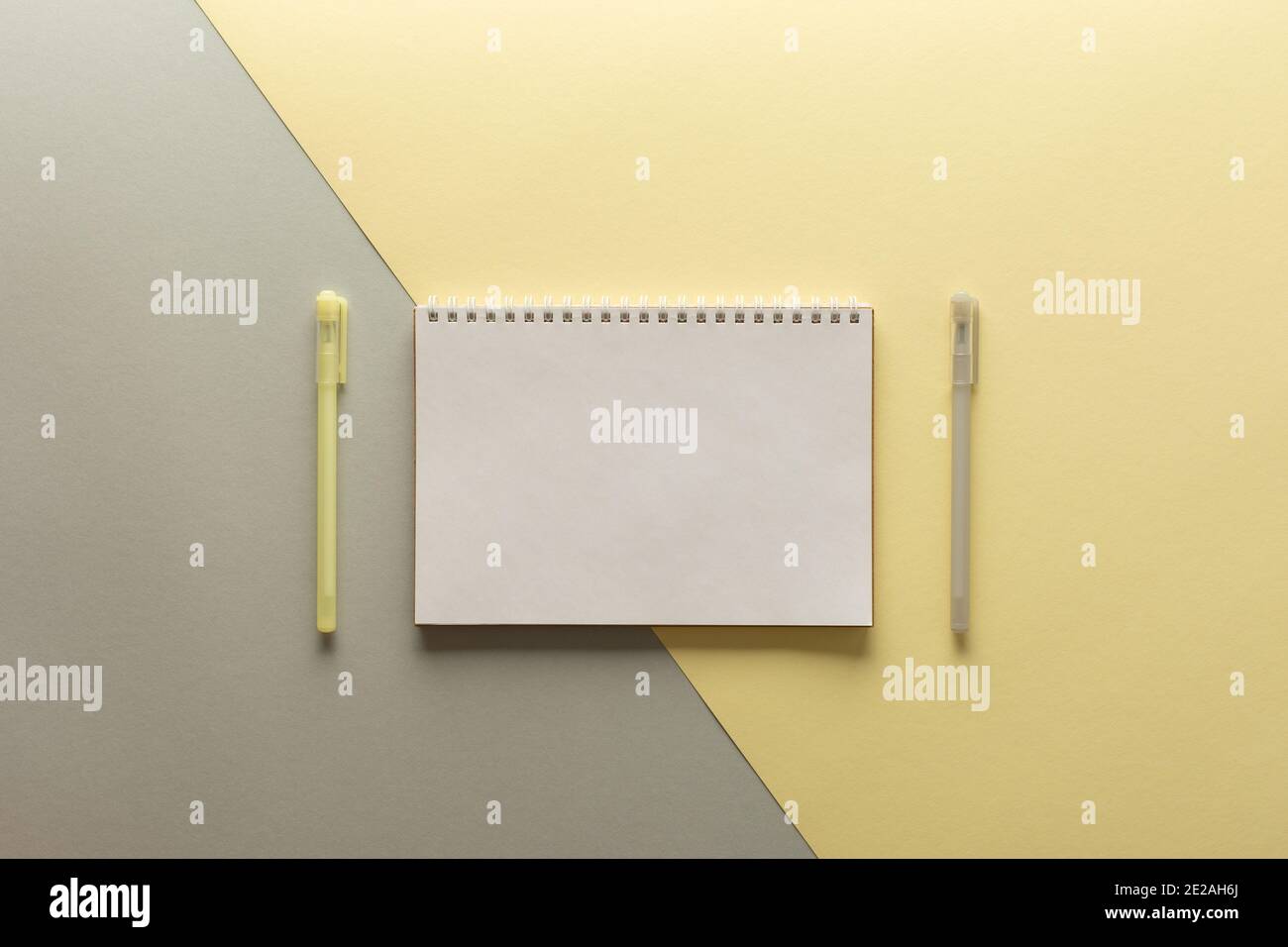 Open spiral notepad on gray and yellow background , notebook and pen ...