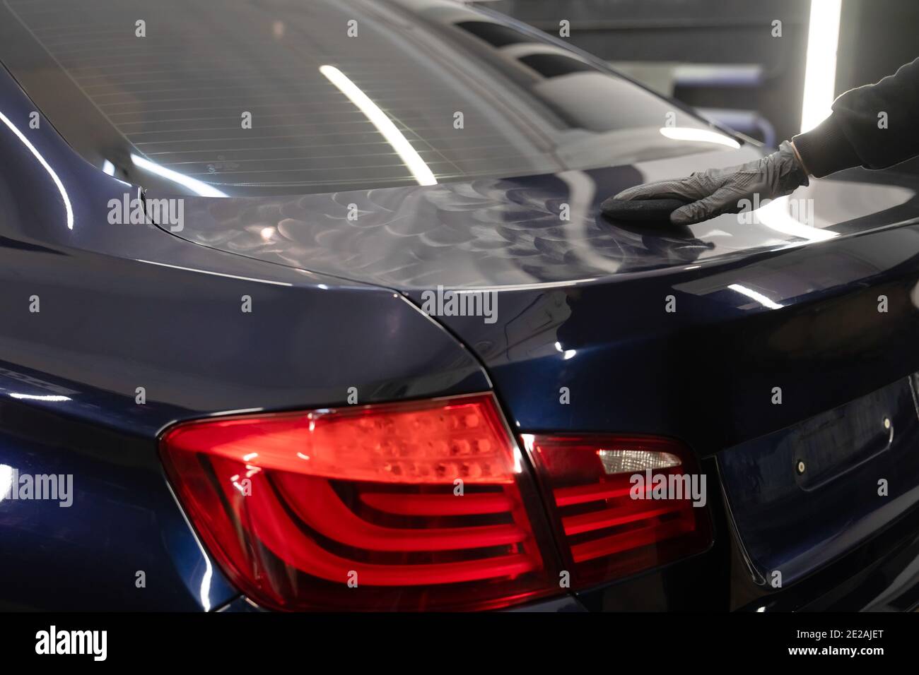 Detailing master applies polishing wax to the car body. Auto detailing ...