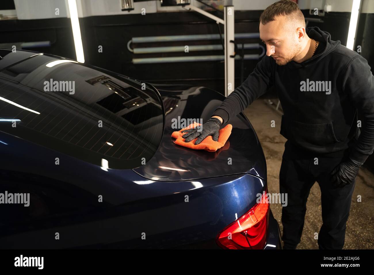Car polishing process. Detailing master applies wax for polishing on ...