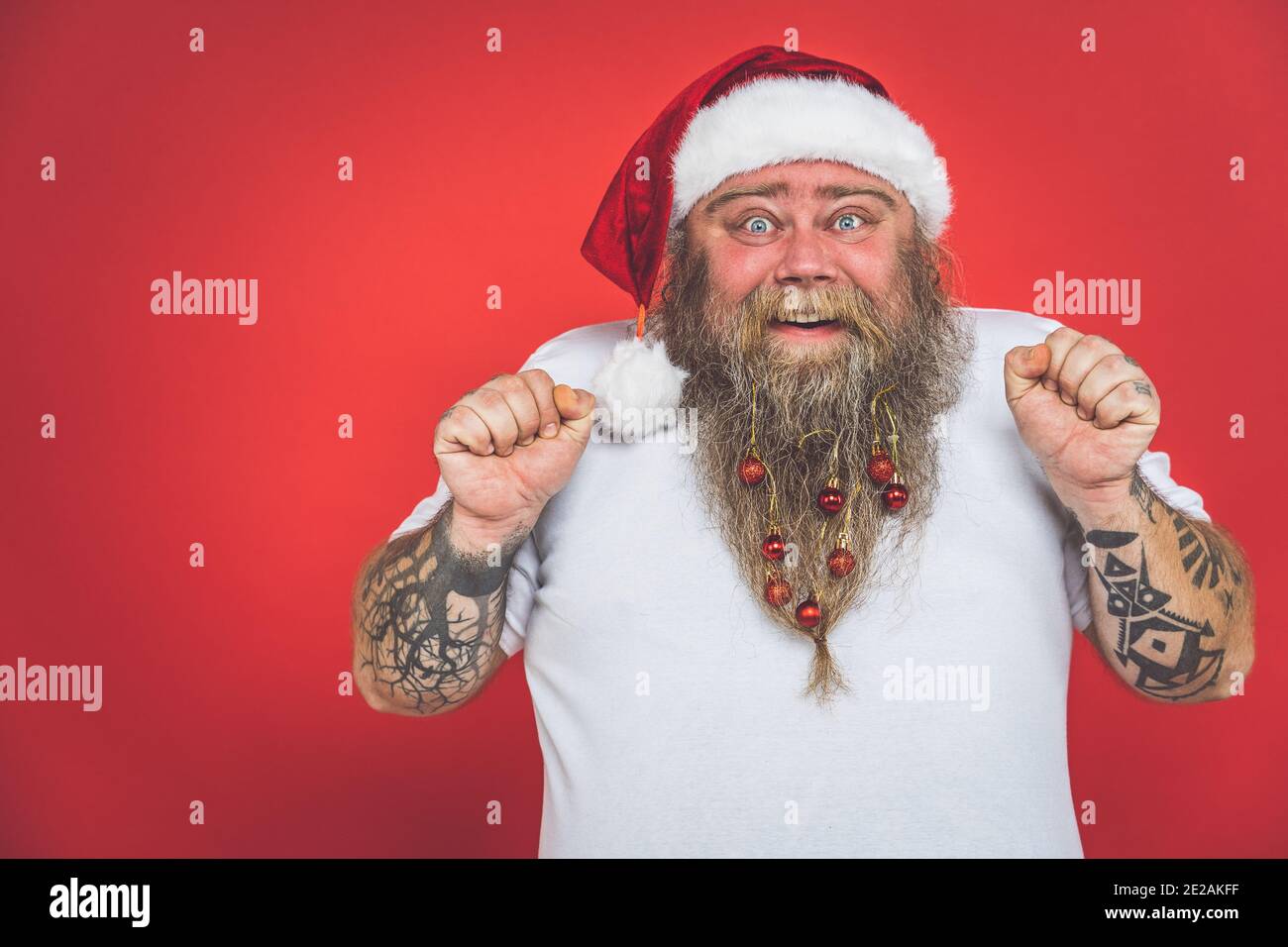 Funny crazy santa claus with tattoo having fun on a red colored ...