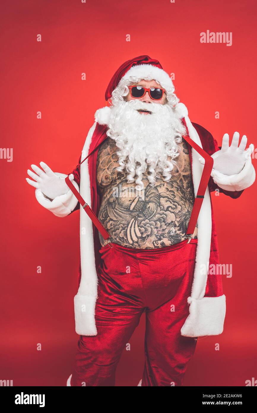 Funny crazy santa claus with tattoo having fun on a red colored ...