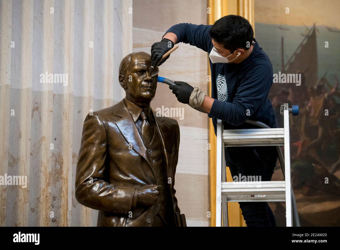 A man works on cleaning up a statue of former President Gerald Ford in ...
