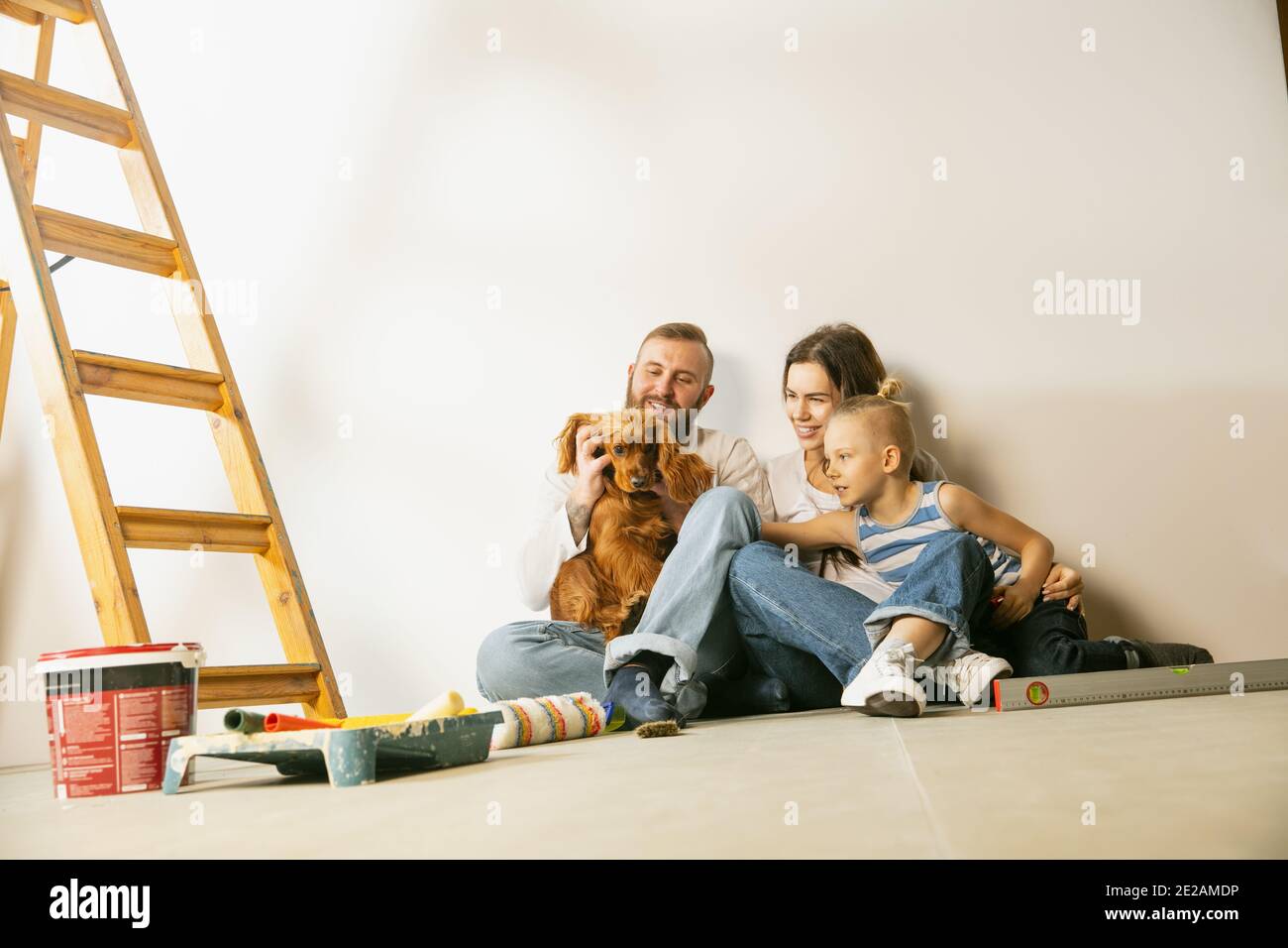Young couple, family doing apartment repair together themselves. Mother ...