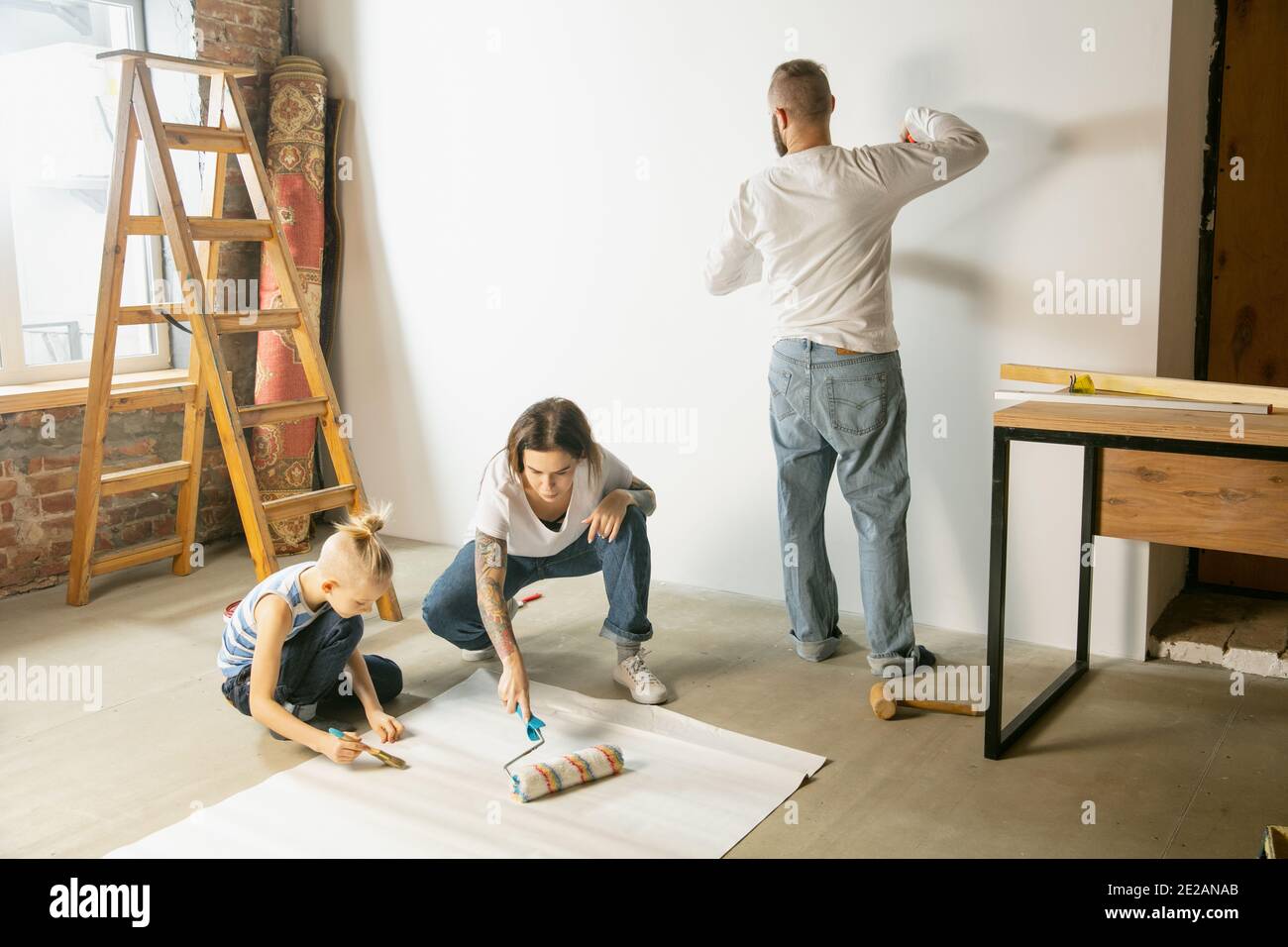 Young couple, family doing apartment repair together themselves. Mother ...