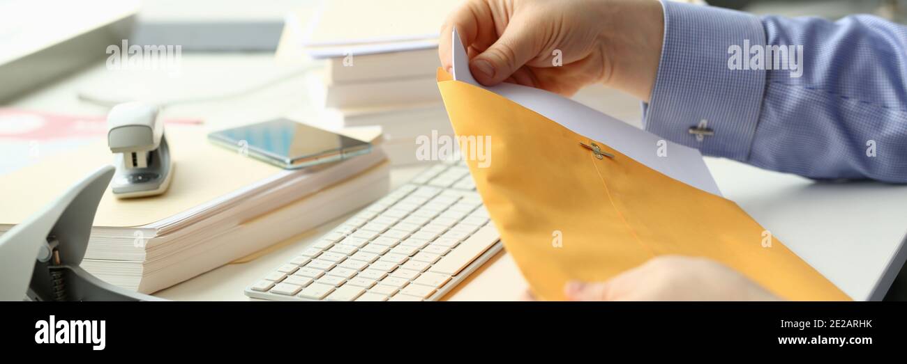Clerk packing documents into folder at desk Stock Photo - Alamy