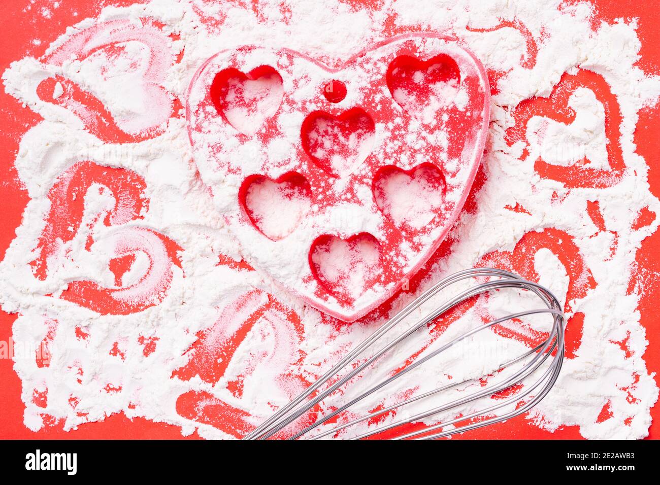Dessert preparation. Red silicone mold and scattered flour on a red ...