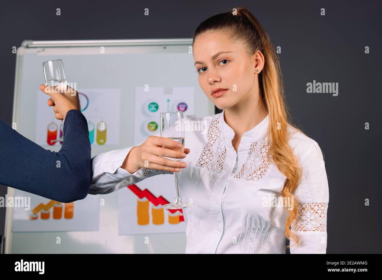 Portrait of a young business woman with a glass of champagne and a new ...