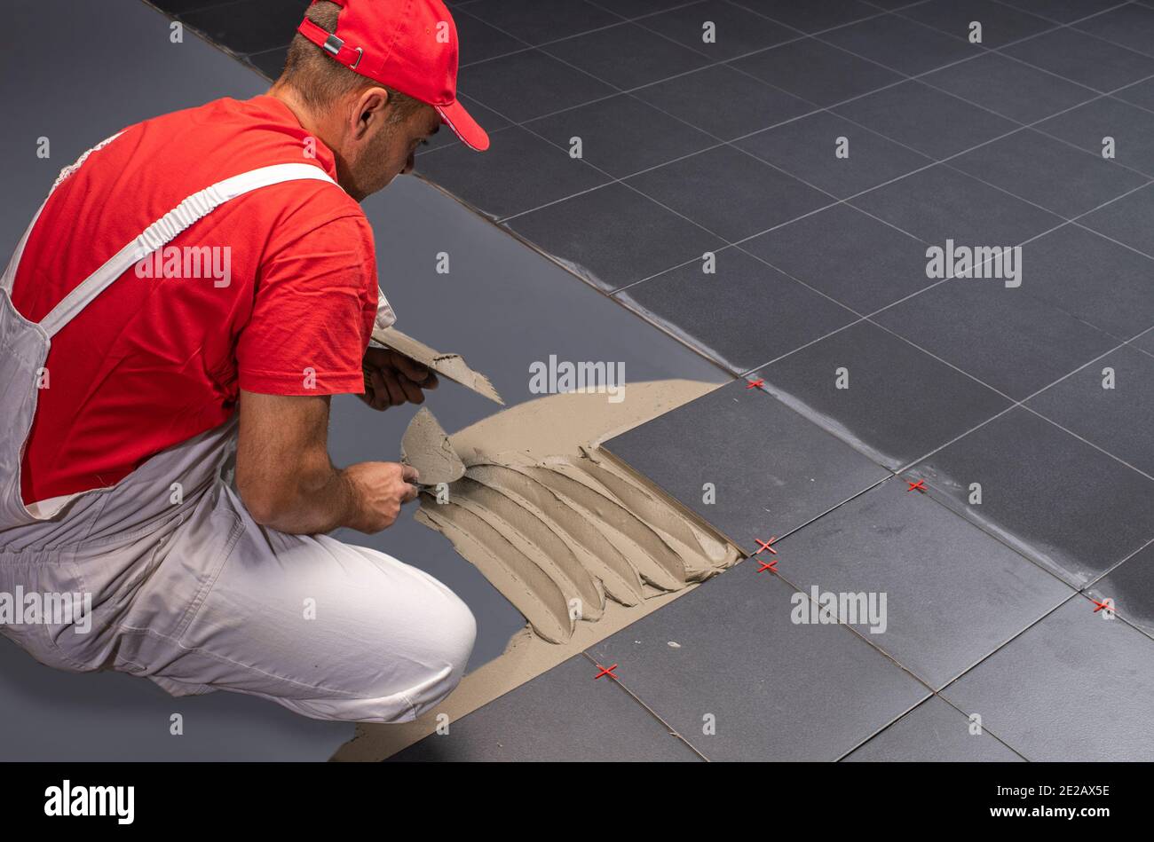 A construction worker putting on new floor tiles Stock Photo - Alamy