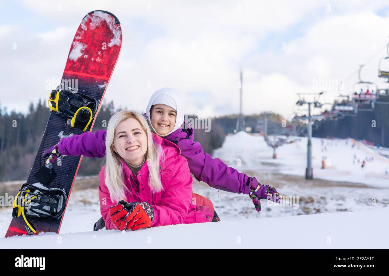 Mother and daughter with snowboards are playing in the snow Stock Photo ...