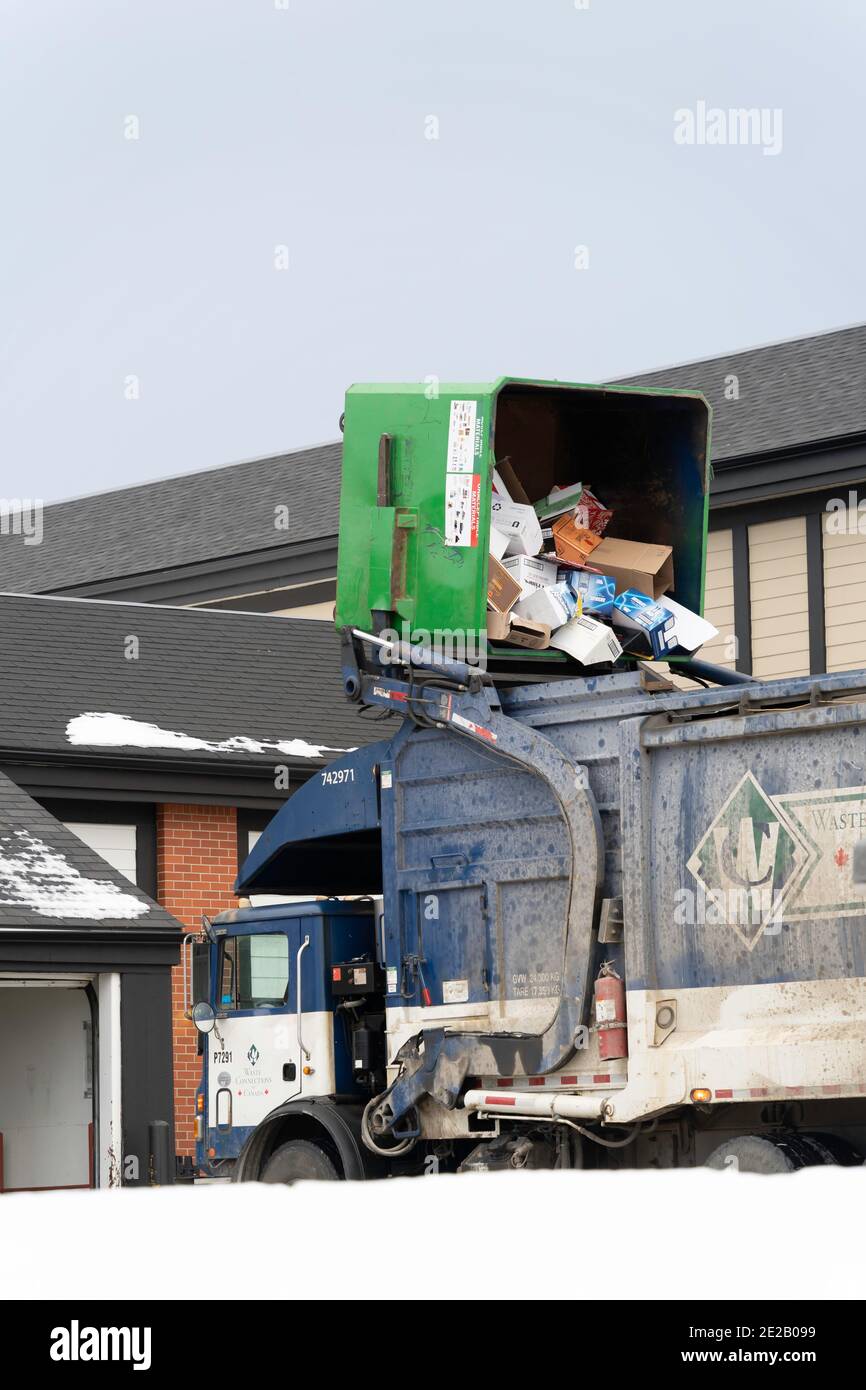 Garbage dump Truck Emptying filled Bin behind strip mall Stock Photo ...