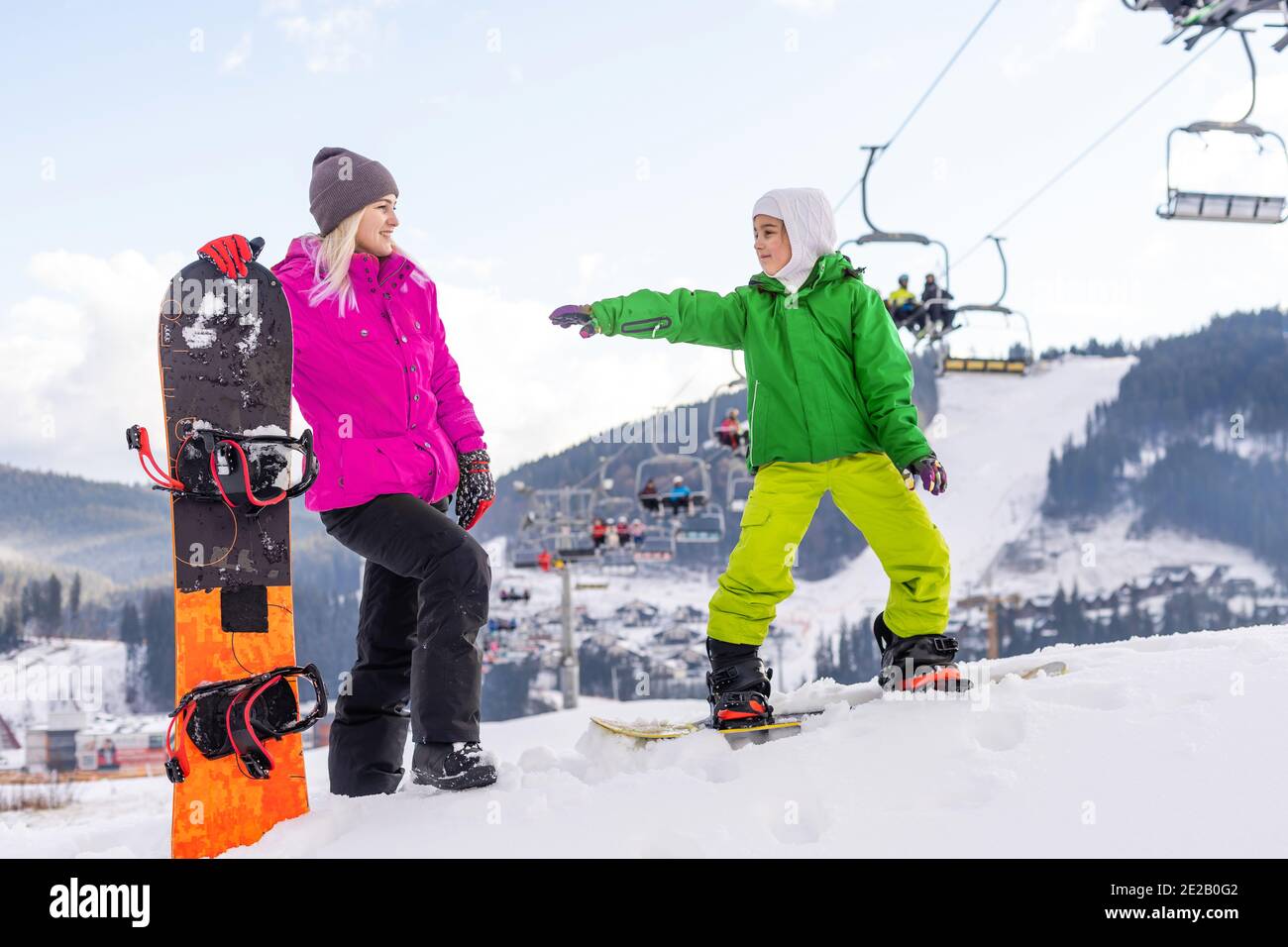 Mother and daughter with snowboards are playing in the snow Stock Photo ...