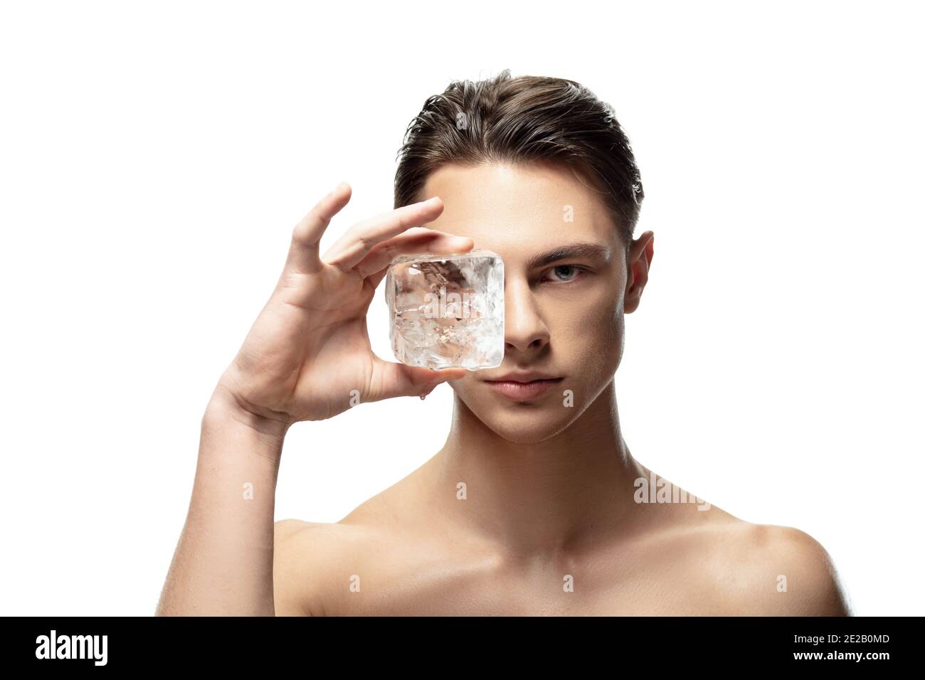 Ice cold. Portrait of young man isolated on white studio background ...