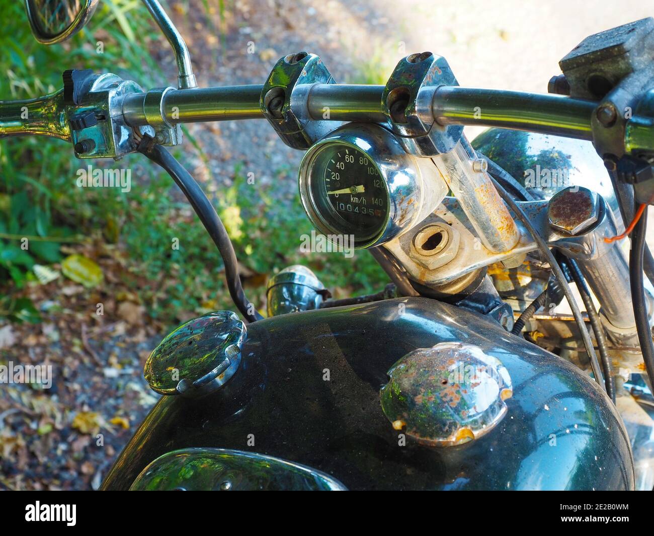 Fragment of motorcycle with a rusting handlebar and speedometer on it ...