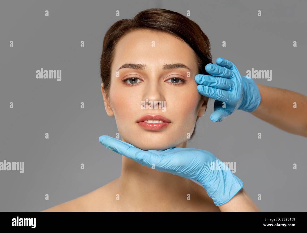 beautiful young woman face and hand in gloves Stock Photo - Alamy