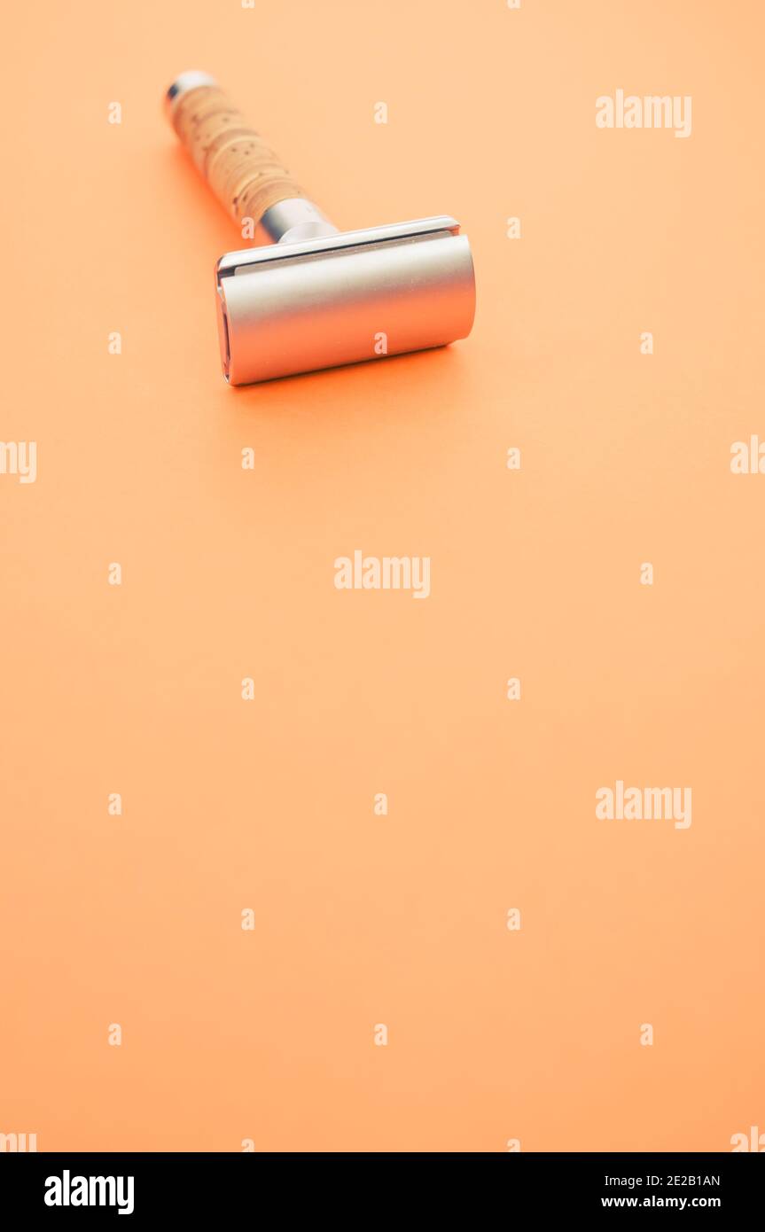 Vertical shot of a t shaped shaving razor on an orange background Stock ...
