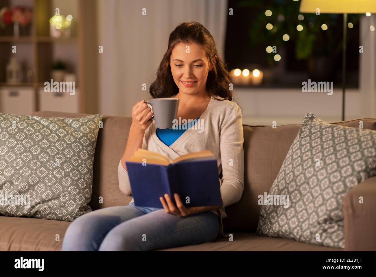 young woman reading book at home in evening Stock Photo - Alamy