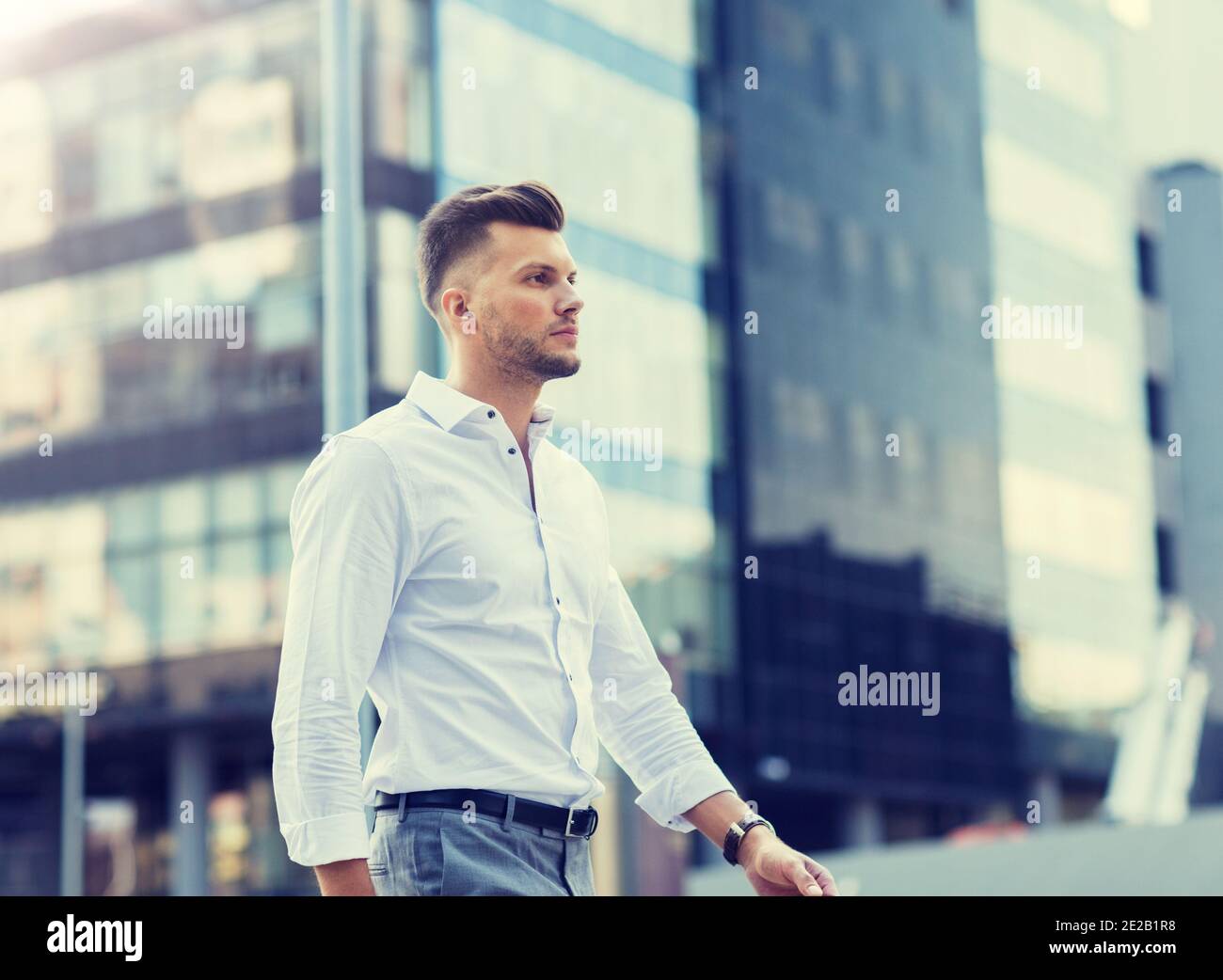 Young man walking along city street hi-res stock photography and images ...