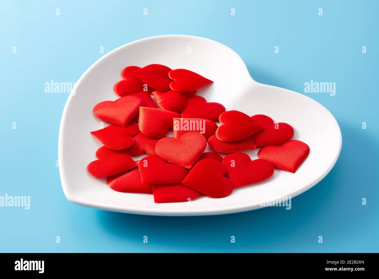 Heart shaped plate with red hearts inside on blue background Stock ...