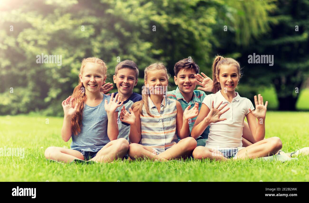 group of happy kids waving hands outdoors Stock Photo - Alamy