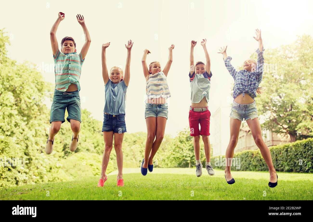 happy kids jumping and having fun in summer park Stock Photo - Alamy
