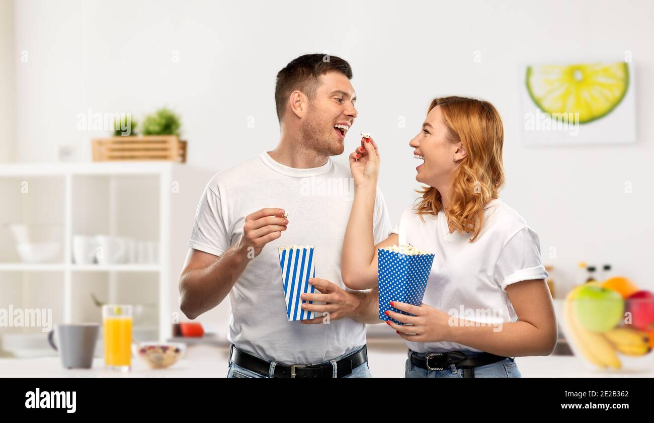 happy couple in white t-shirts eating popcorn Stock Photo - Alamy