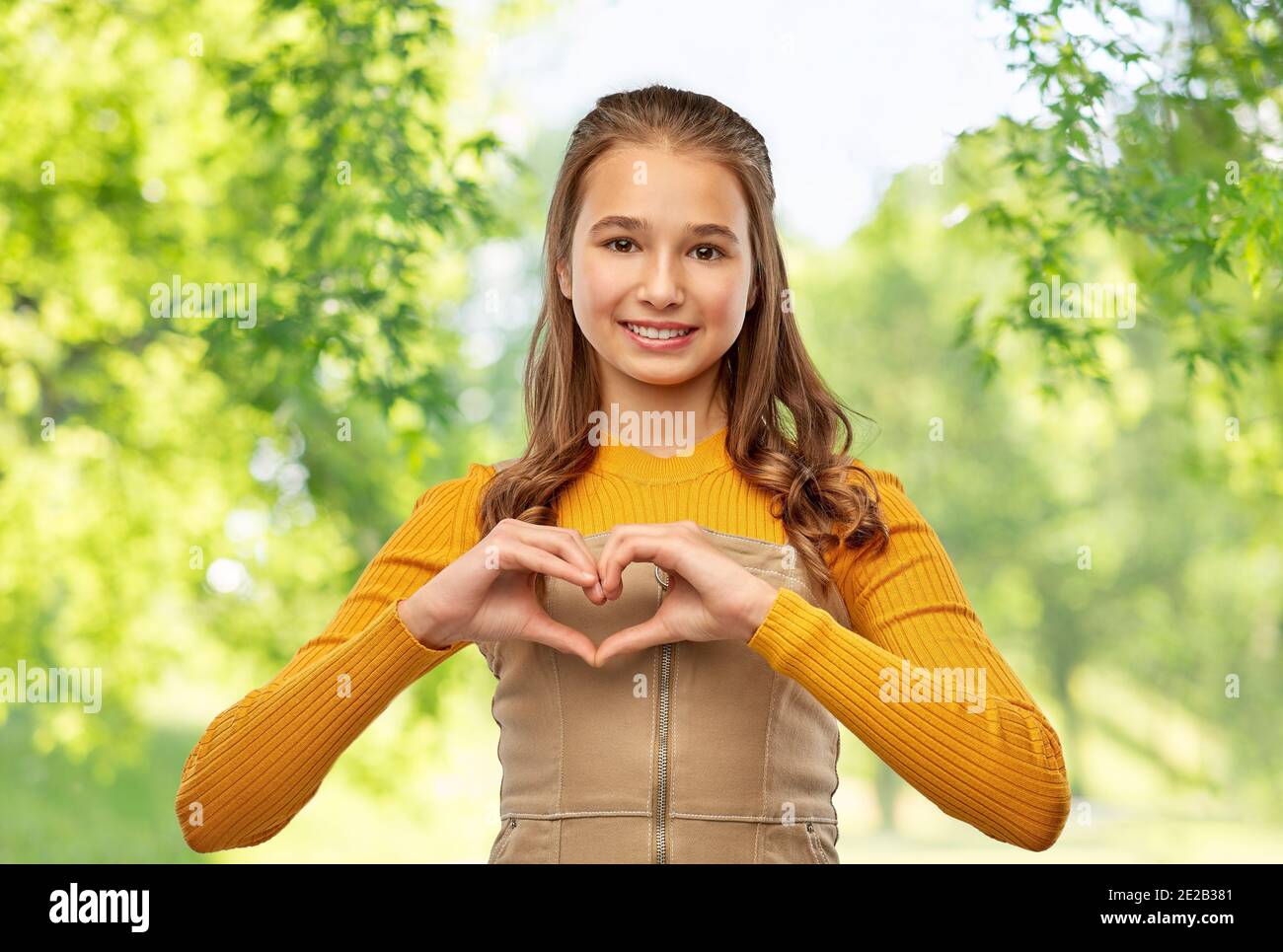 smiling teenage girl making hand heart Stock Photo - Alamy